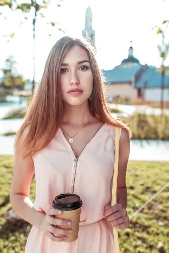 여자 학생 여름 도시는 가을 봄 분홍색 드레스 커피 차와 함께 유리에 손 공원에서 점심 간식 배경은 나무의 공원입니다 세련 되 고 세련 된 패션 라이프 스타일 개념에 대한