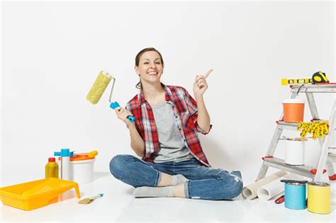 캐주얼 옷 바닥 페인트 롤러 흰색 배경에 고립 된 재건축 아파트에 대 한 악기에 앉아 여자 배경 화면 접착 페인팅 도구에 대 한 액세서리입니다 수리 가정 개념입니다 개선에