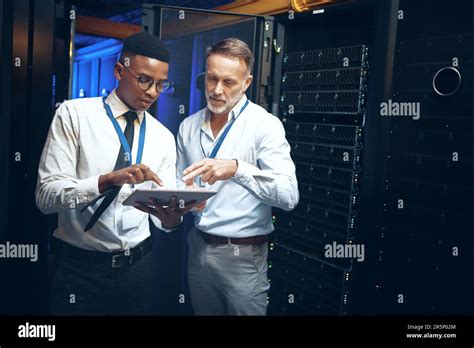doing their daily inspections two technicians using a digital tablet while working in a server