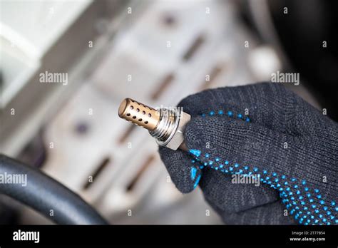 oxygen sensor for gasoline and diesel engines in the hand against car