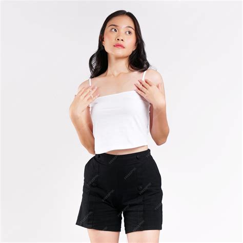 Premium Photo A Woman Wearing A White Top And Black Shorts Stands In