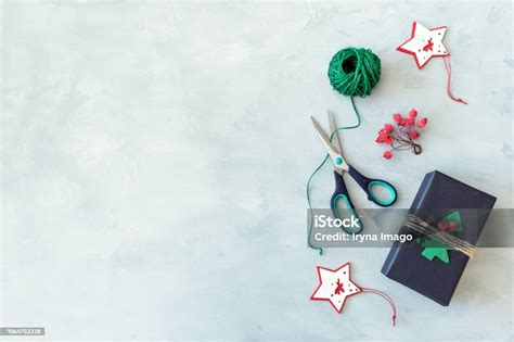 크리스마스 래핑입니다 선물 상자 크 래 프 트 종이 꼬기 침 엽 수 가지 붉은 열매 가 위 회색 콘크리트 바탕에 배치와 함께 현재 크리스마스 선물 팩 포장 장식 평면 배치