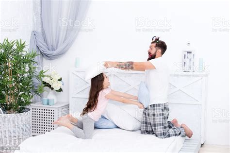 우리는 함께 가족을 만듭니다 행복한 가족 아버지와 딸의 가족은 침실에서 즐거운 시간을 보냅니다 아버지와 어린 아이는 베개 싸움을