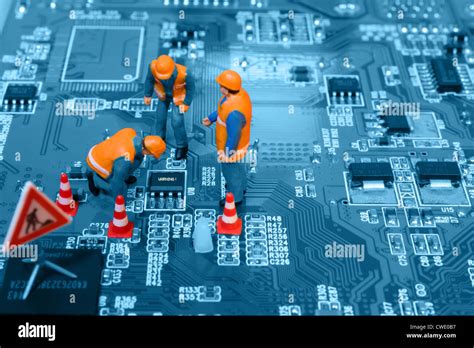 Miniature Engineers Fixing Error On Chip Of Circuit Board Computer Repair Concept Close Up