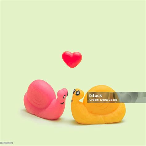 사랑 개념에 커플 분홍색과 노란색 부드러운 달팽이 장난감은 그 위에 빨간 하트 젤리 사탕으로 서로 가까이 있습니다 N파스텔 라임 그린 배경 귀여운에 대한 스톡 사진 및 기타
