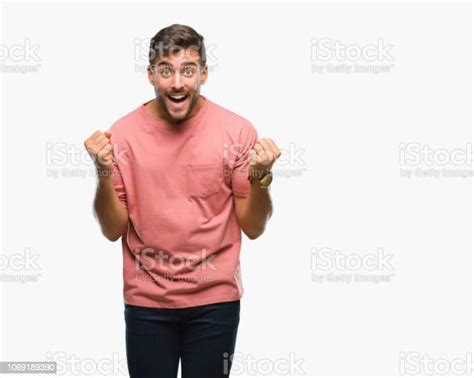 격리 된 배경 축 하에 잘생긴 젊은이 놀라게 무기 제기와 성공을 위한 깜짝 놀라게 고 눈을 엽니다 우승자 개념입니다 긍정적인 감정 표현에 대한 스톡 사진 및 기타 이미지