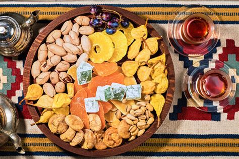 배 무화과 나무 접시에 파인애플 터키과자 견과류와 말린 과일의 혼합 테이블에 달콤한 차와 안경 동양 과자의 평평한 전망 디저트와 접시 복사 공간으로 모의 0명에 대한 스톡