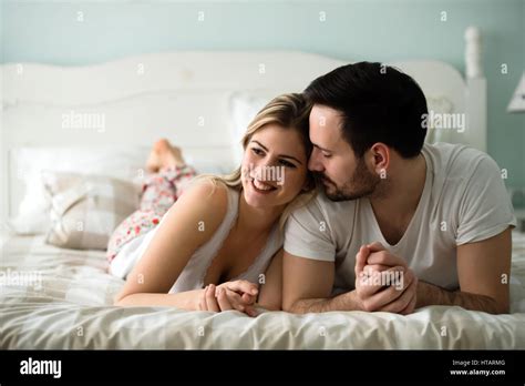Couple In Love Wearing Pajamas Cuddling While Lying In Bed Stock Photo Alamy