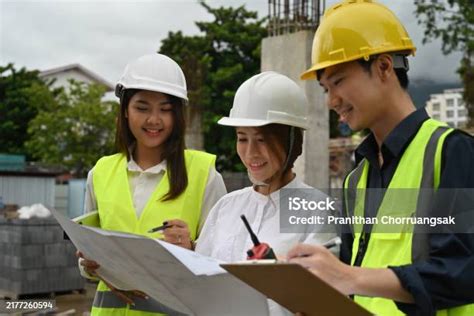 건축 프로젝트 계획 및 건축을 위한 엔지니어링 팀의 초상화 건설 현장에서의 개발 및 안전성 평가 논의를 위해 여성과 남성 계약자가 함께 3 명에 대한 스톡 사진 및 기타