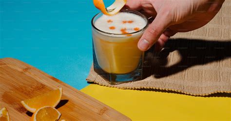 오렌지 주스 한 잔을 들고 있는 사람 사진 Unsplash의 칵테일 이미지