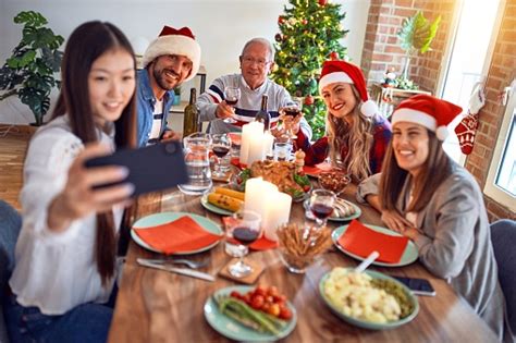 산타 클로스 모자를 입고 아름 다운 가족 회의 미소 행복 하 고 자신감 집에서 크리스마스를 축하하는 스마트 폰으로 구운 칠면조를 먹는 셀카 Blessing에 대한 스톡 사진