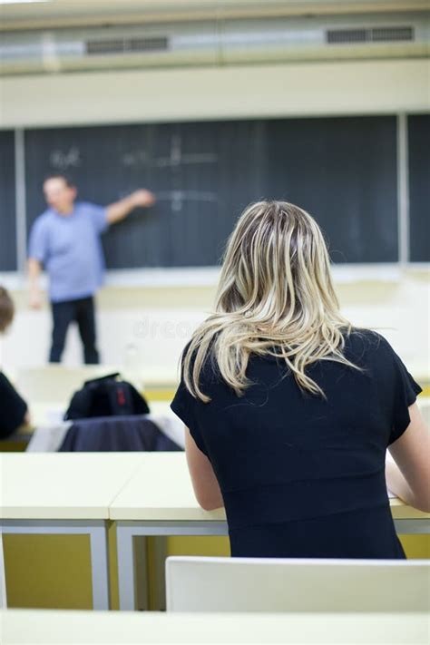 Estudiante Universitario De Sexo Femenino Que Se Sienta En Una Sala De Clase Imagen De Archivo