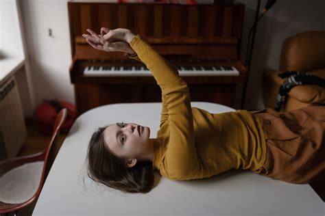 배경 화면 여자들 모델 갈색 머리의 뷰어를보고 측면보기 무기를 들고 바지 멜빵 터틀넥 치마 뒤에 누워 표 피아노 보케 의자 실내의 여성