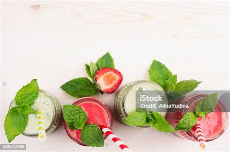 장식 프레임 녹색과 빨간색 과일 스무디 딸기와 사과 평면도의 밀 짚 민트 잎 유리 항아리에 화이트 나무 보드 배경 공간을 복사