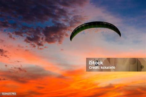 부드러운 초점에 비행 낙하산의 스카이 다이빙 일몰 풍경 파라 모터 플라잉 실루엣과 선 세트 일몰과 함께 저녁 하늘에서 비행 패러 글라이더의 실루엣 도전에 대한 스톡 사진 및