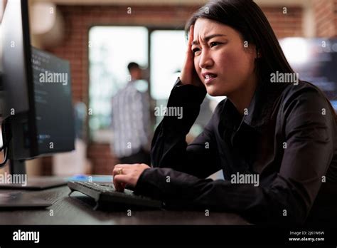 Confused Tech Engineer Sitting Doubtful At Computer Trying To Solve Network Processing Errors