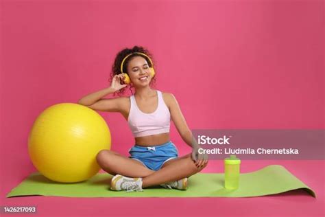분홍색 배경에 요가 매트에 헤드폰을 가진 아름다운 아프리카 계 미국인 여성 분홍에 대한 스톡 사진 및 기타 이미지 분홍 요가 20 24세 Istock