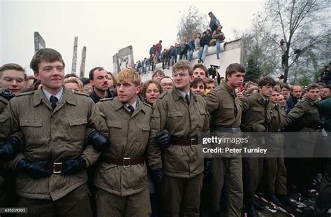 East German Soldiers Link Arms During The Dismantling Of The Berlin
