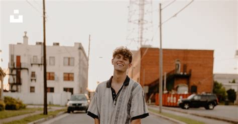 흰색과 검은색 긴팔 셔츠와 파란색 데님 청바지를 입은 여자가 도로에 서 있다 사진 Unsplash의 무료 길 이미지