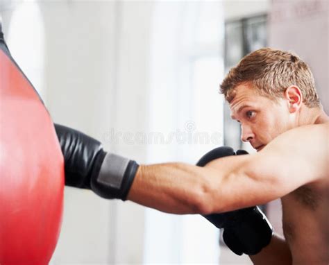 Strength And Focus A Young Boxer Practicing With A Punching Ball