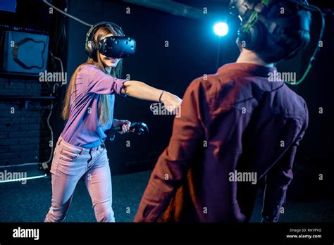 Man And Woman Playing Game Using Virtual Reality Headset And Gamepads