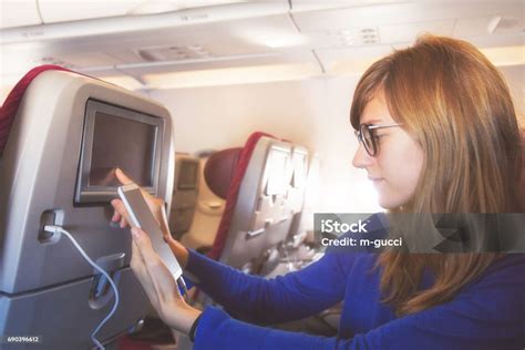 소녀는 비행기에서 핸드폰과 터치 스크린을 사용 하 여입니다 Usb 케이블에 대한 스톡 사진 및 기타 이미지 Usb 케이블 관광객 날기 Istock