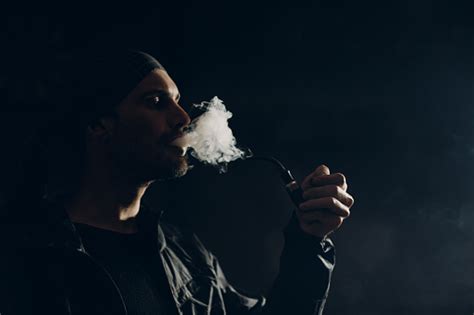 남자는 어두운 배경에 파이프를 흡연 프로필 세로입니다 검은색에 대한 스톡 사진 및 기타 이미지 검은색 검정색 배경 꿈꾸기