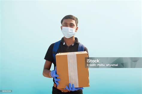 평범한 배경에 대한 골판지 상자를 들고 젊은 인도 배달 남자의 초상화 20 24세에 대한 스톡 사진 및 기타 이미지 20