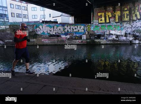 A Man Runs Along The Tow Path By The Regent S Canal Under A Bridge In The Early Morning Winter