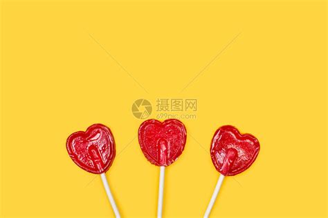黄色背景上的三个红色心形棒糖高清图片下载 正版图片503675811 摄图网