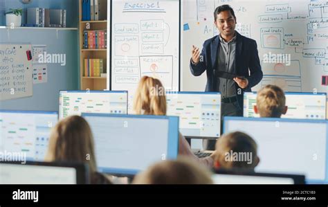 Elementary School Computer Science Class Teacher Uses Digital Tablet Explains Lesson To