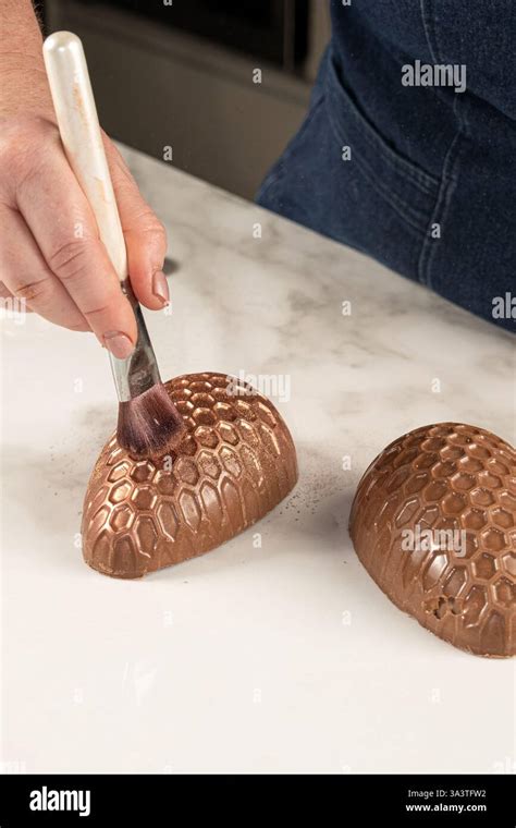 Confectioner Putting Edible Copper Powder On A Chocolate Easter Egg With A Honeycomb Texture