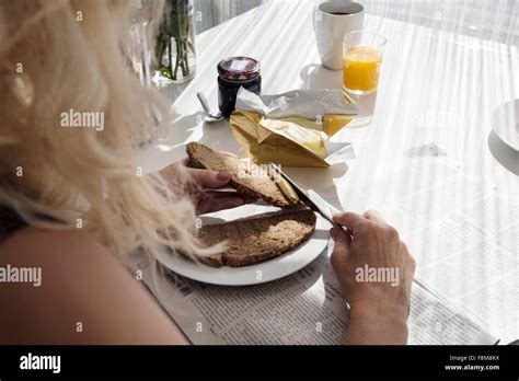 Over Shoulder View Of Mature Woman Spreading Butter Onto Bread Stock Photo Alamy