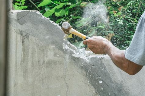 premium photo hand of worker using hammer smashing and demolish on