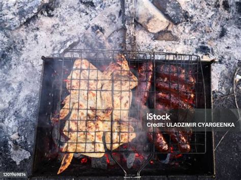 그릴 신선한 고기 튀김 치킨 바베큐 소시지 케밥 햄버거 야채 바베큐 바베큐 해산물 구운 고추와 양파 클로즈업 햇볕이 잘 드는 야외 요리사가 그릴에서 고기를 돌립니다 고기에