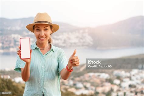 해변 휴양지 마을에서 모자를 쓴 여성 여행자가 스마트폰 화면을 보여줍니다 관광 및 운송을 위한 디지털 애플리케이션 30 34세에 대한 스톡 사진 및 기타 이미지 Istock
