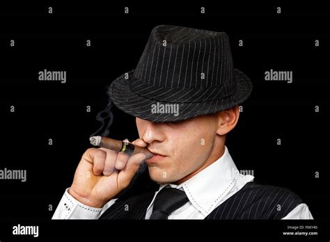 young gangster with hat smoking cigar, studio shot Stock Photo - Alamy