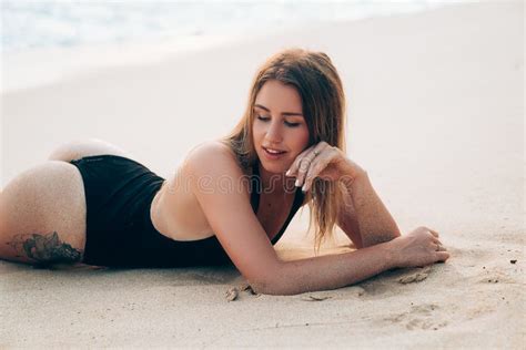 Close Up Of A Girl Sunbathing On The Beach Lies On Her Stomach Shows