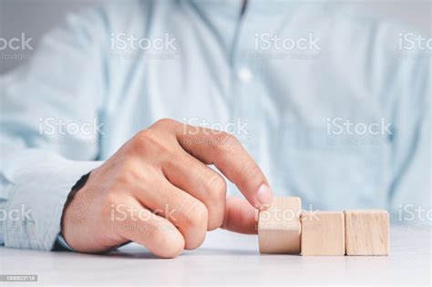 파란 셔츠를 입은 사업가가 빈 나무 블록을 손으로 정리했다 흰색 나무 테이블에 배치됩니다 비즈니스 전략 및 실행 계획 공간을