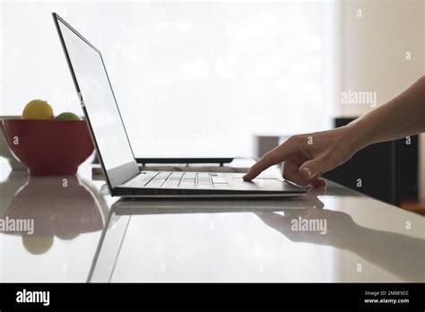 Close Up Of Female Hand Scrolling On Mouse Pad Of Modern Laptop