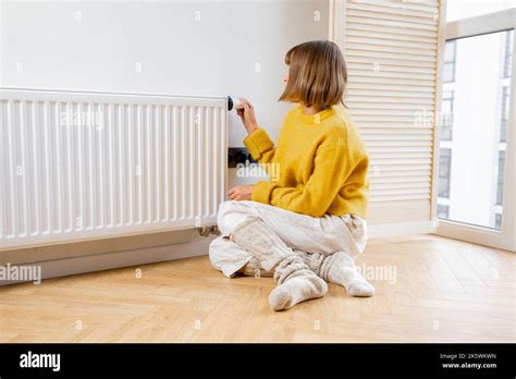 Woman Controls Room Temperature With A Thermostat Stock Photo Alamy