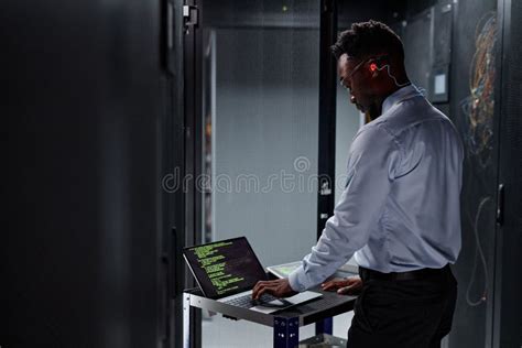 Network Engineer Using Laptop While Setting Up Servers In Data Center