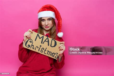 현수막을 들고있는 산타 모자를 쓴 미소 짓는 여자 미친 크리스마스 나쁜 기분 휴일 블루스 25 29세에 대한 스톡 사진 및 기타