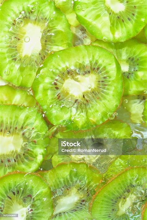 물 배경에서 녹색 키위 과일 조각의 클로즈업 보기 유리 벽에 매크로 거품이 있는 냉각 과일 음료의 질감 플랫 디자인 세로 이미지