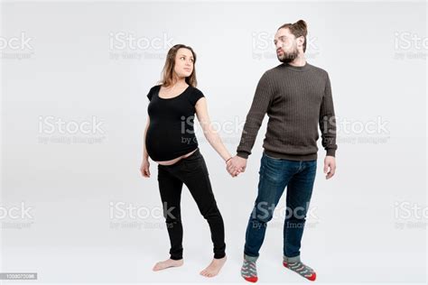 젊은 매력적인 커플 캐주얼 옷 수염 남자와 임산부 함께 서 손에 손을 잡고 서로 보고 흰색 배경 위에 고립 가족에 대한 스톡 사진 및 기타 이미지 Istock