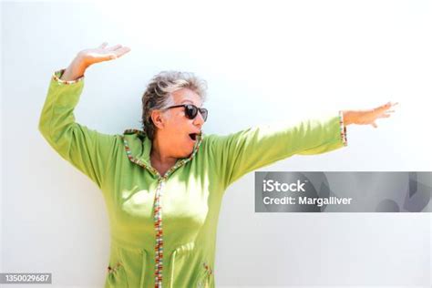 행복한 얼굴을 가진 회색 짧은 머리를 가진 노인 여성은 흰색 배경에 팔을 흔들고 있습니다 60 69세에 대한 스톡 사진 및 기타 이미지 60 69세 개념 노인