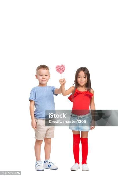 카메라를 보고 하 고 캔디와 함께 웃 고 세련 된 옷을 입고 귀여운 꼬마의 전체 길이 초상화 귀여운에 대한 스톡 사진 및 기타