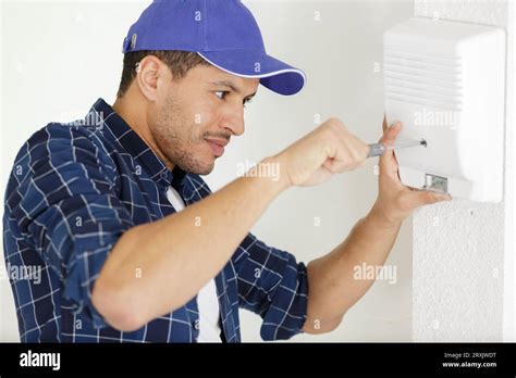 Technician Installing Security System Door Sensor Using Screwdriver