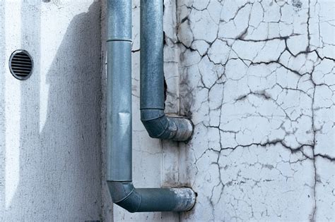 벽에 두 개의 알루미늄 배수관이 치장 벽토와 페인트의 균열로 덮여 있습니다 0명에 대한 스톡 사진 및 기타 이미지 0명 강철 거친 Istock