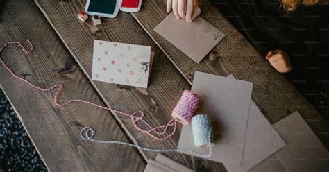 테이블에 앉아 공예품을 만드는 여자 사진 Unsplash의 포장 이미지